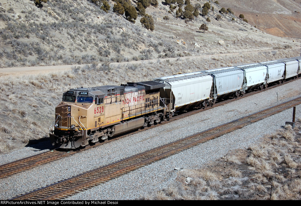 UP AC-4400CW #6528 in the DPU on an eastbound UP grain train that has just passed under the Echo ...